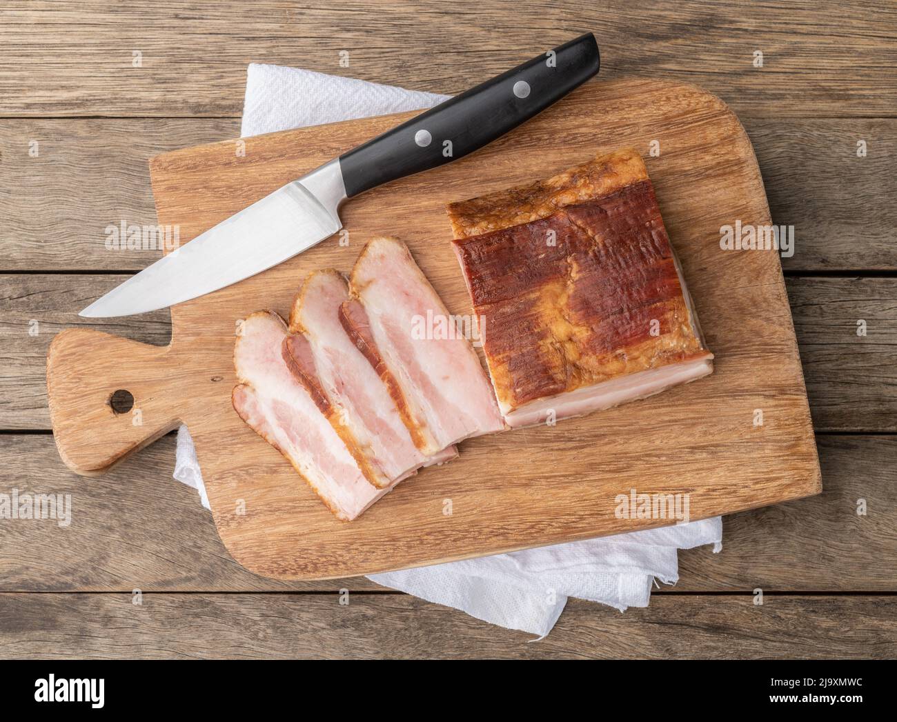 Smoked bacon with slices and knife over wooden board Stock Photo - Alamy