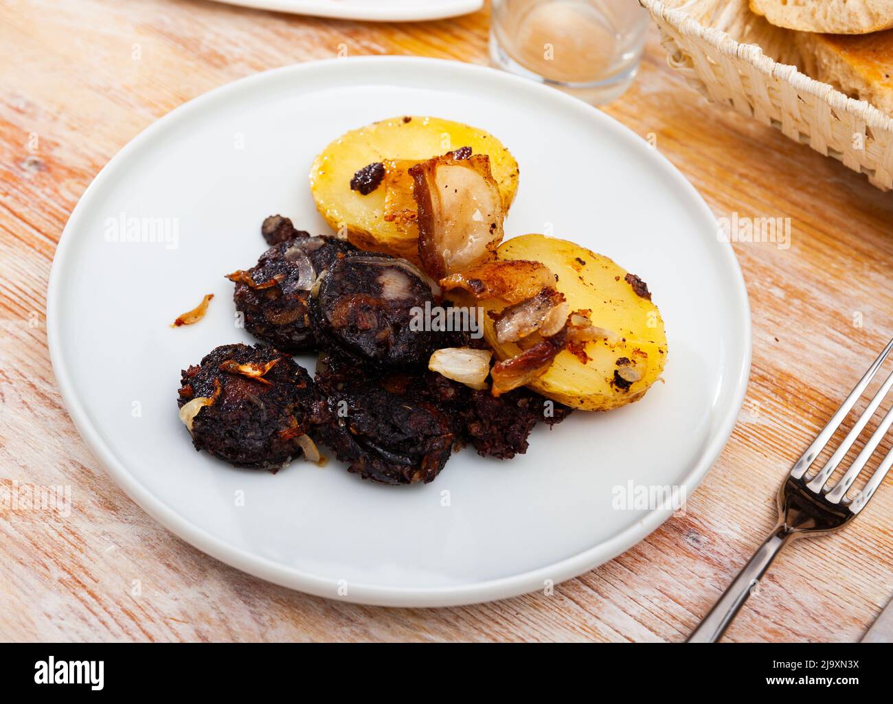 Fried blood sausage morcilla served with baked potatoes Stock Photo - Alamy