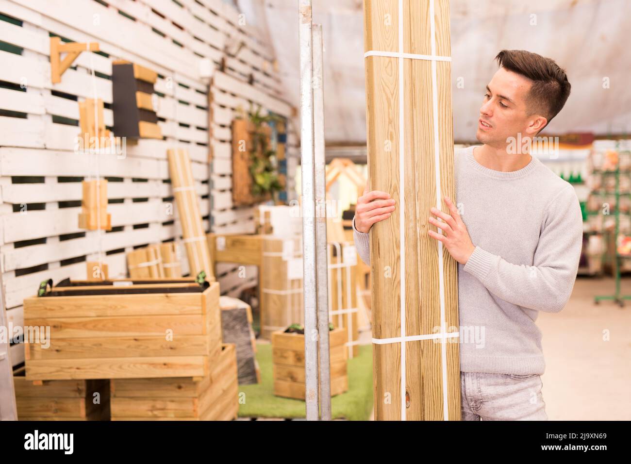 Portrait of positive man with purchases in hardware store Stock Photo ...