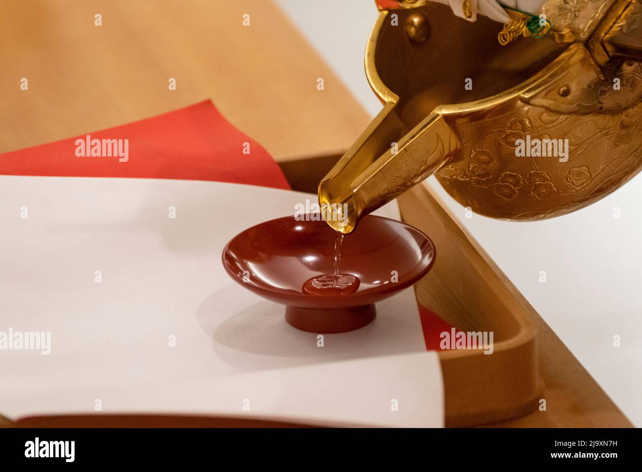 Pouring sake in preparation for the ceremony of the relatives' cup ...