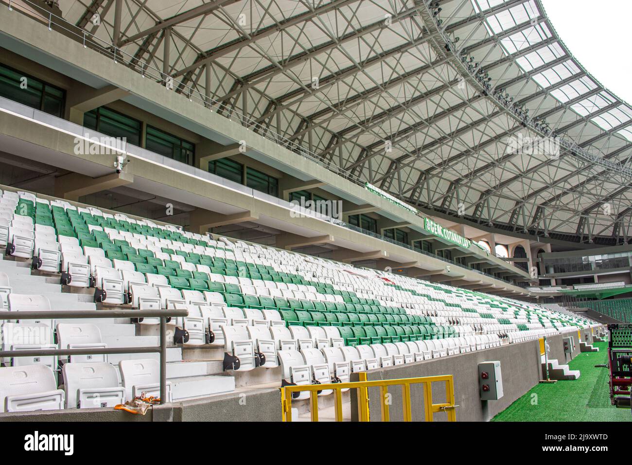 Empty seats in modern football stadium with roof. Green and white ...