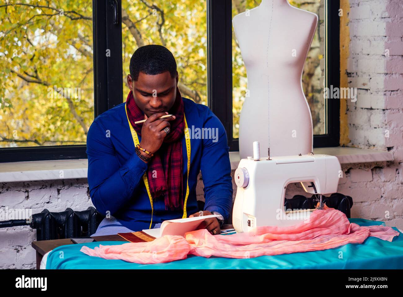 portrait of a handsome african man smiling seamstress with sewing ...