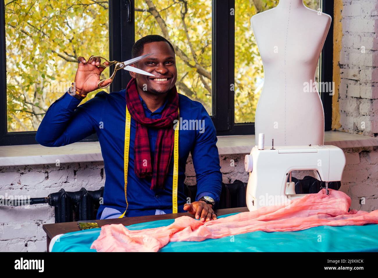 portrait of a handsome african man smiling seamstress with sewing ...