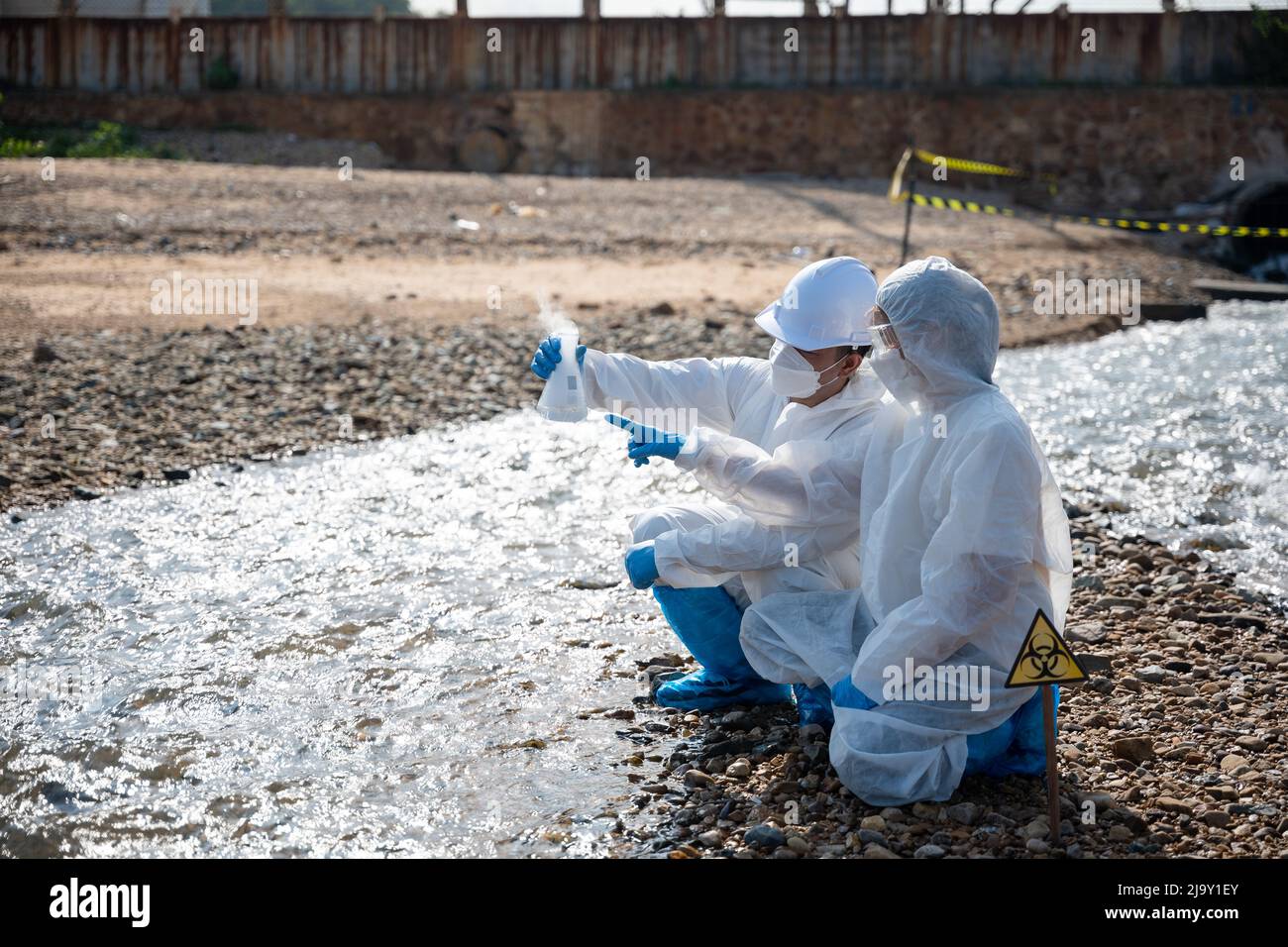 Ecologist sampling water from river with test tube glass and have white ...
