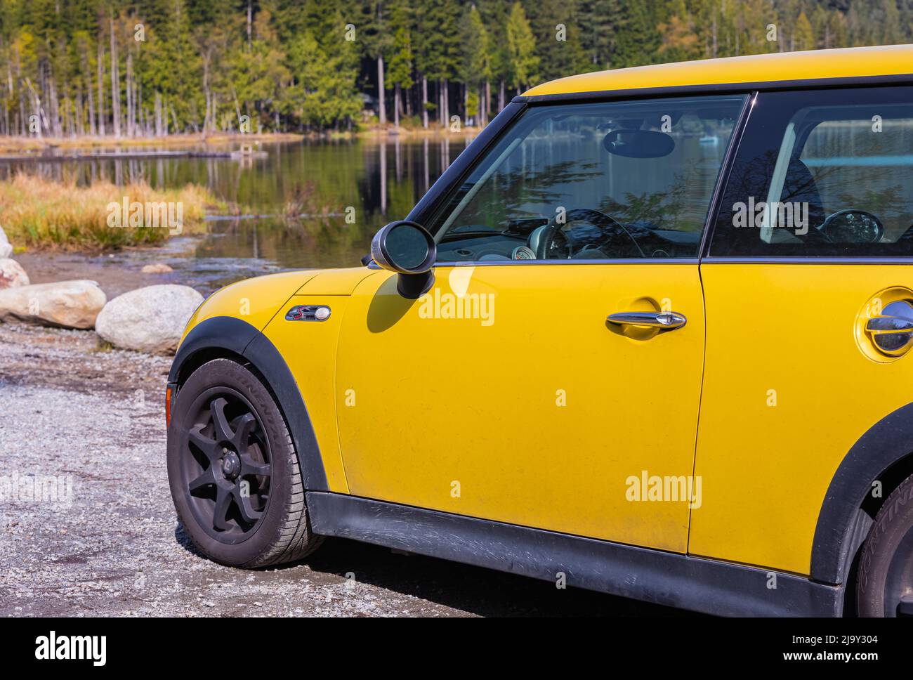 Side view of a Yellow Mini Cooper S car on natural background. Yellow ...