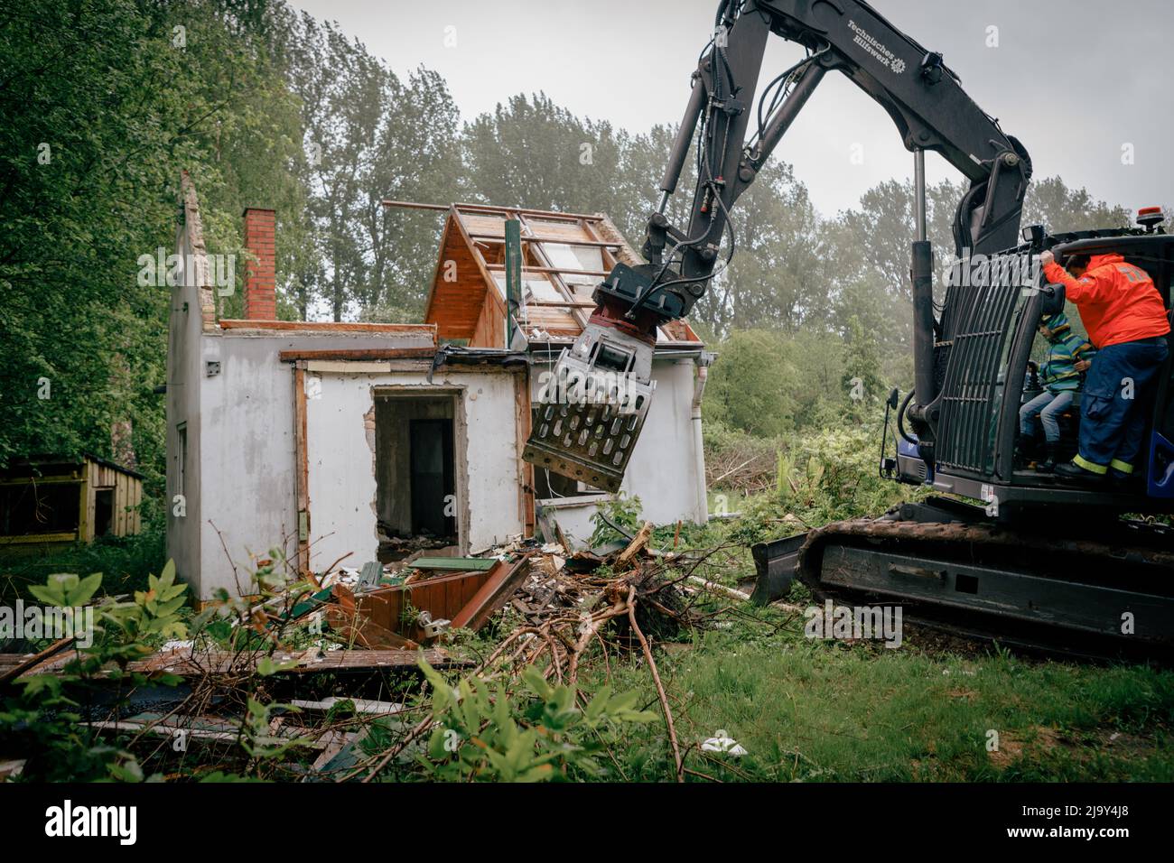 a ruined house is demolished with an excavator from the THW technical ...