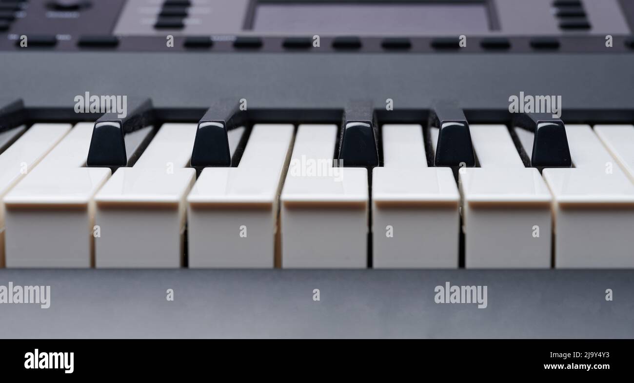 Electronic piano keys close up view on blurred buttons and screen ...