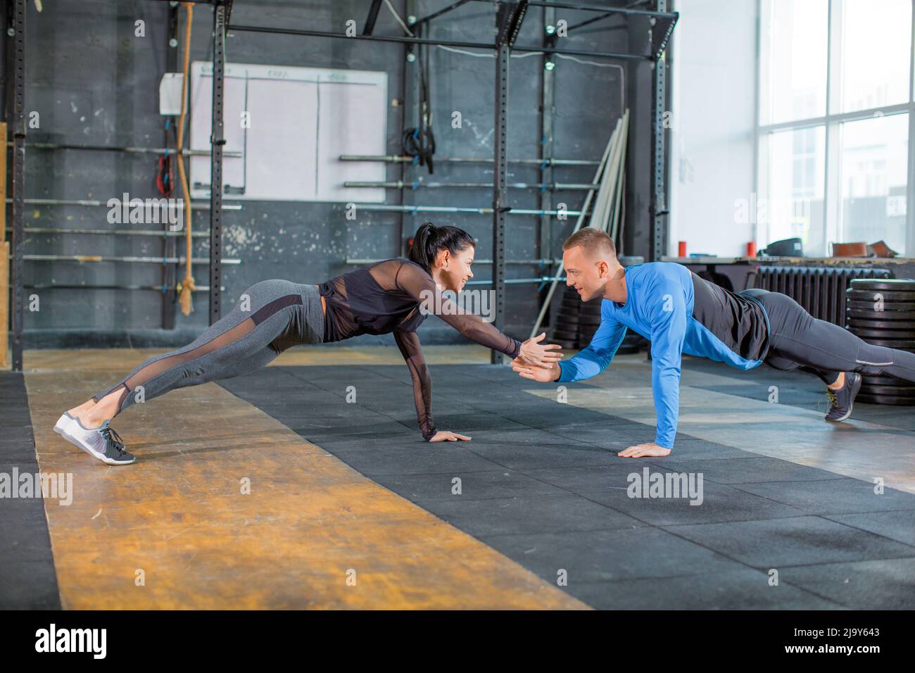 Push-ups together. Healthy couple in gym, workout with own body weight ...