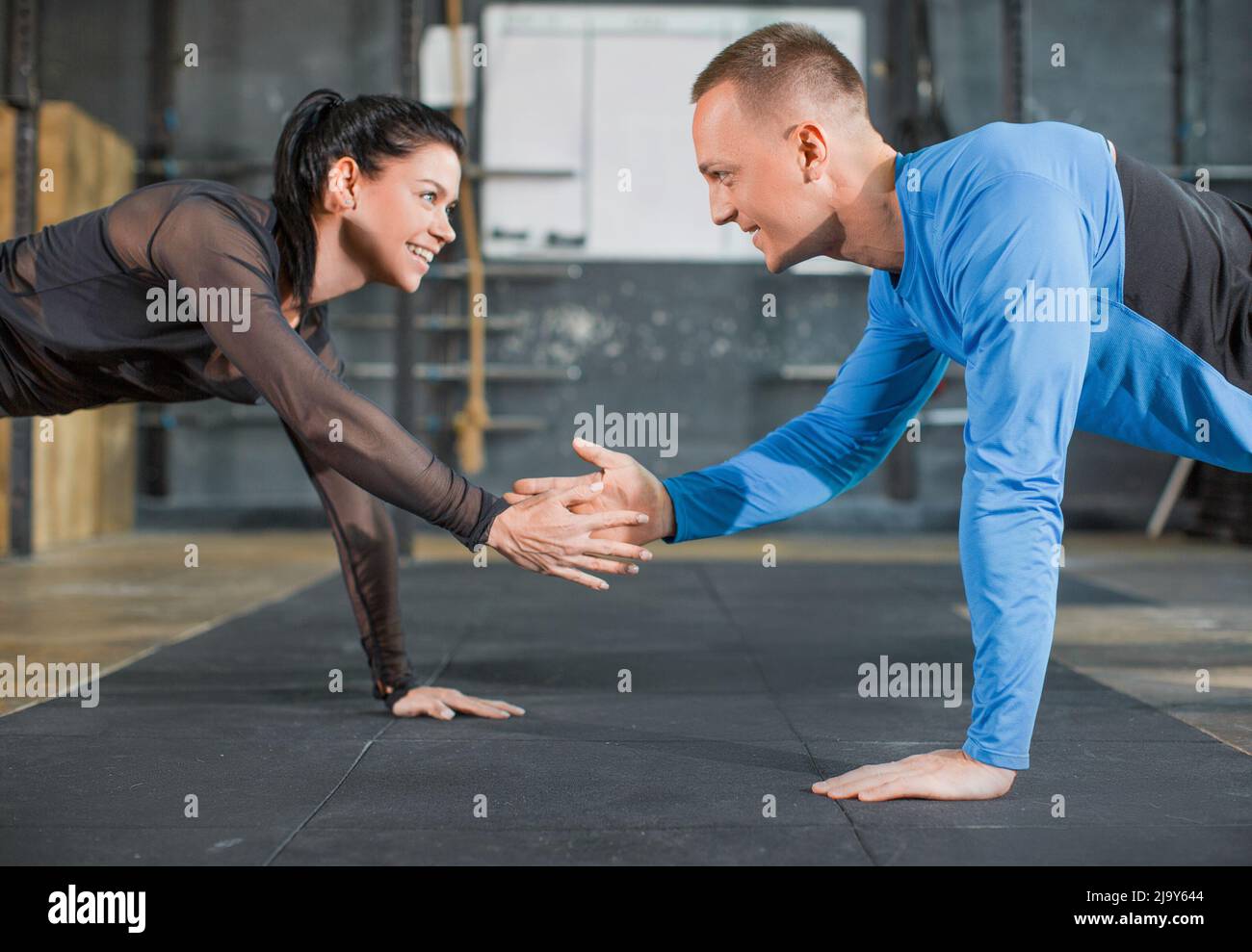 Sporty couple doing push ups together and giving vife. Close up photo ...