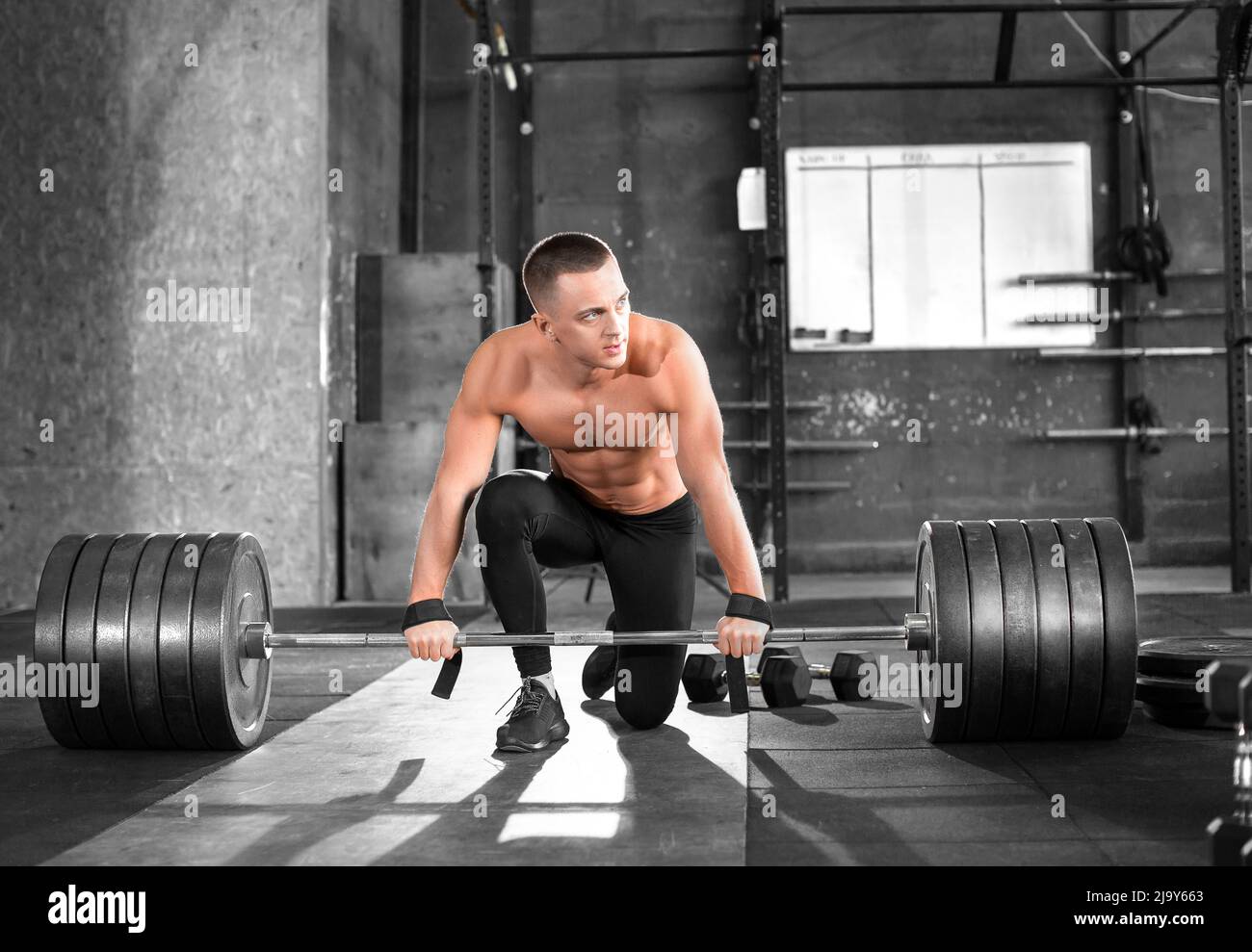 Tired muscular man win a barbell in gym. Preparing to do deadlift ...