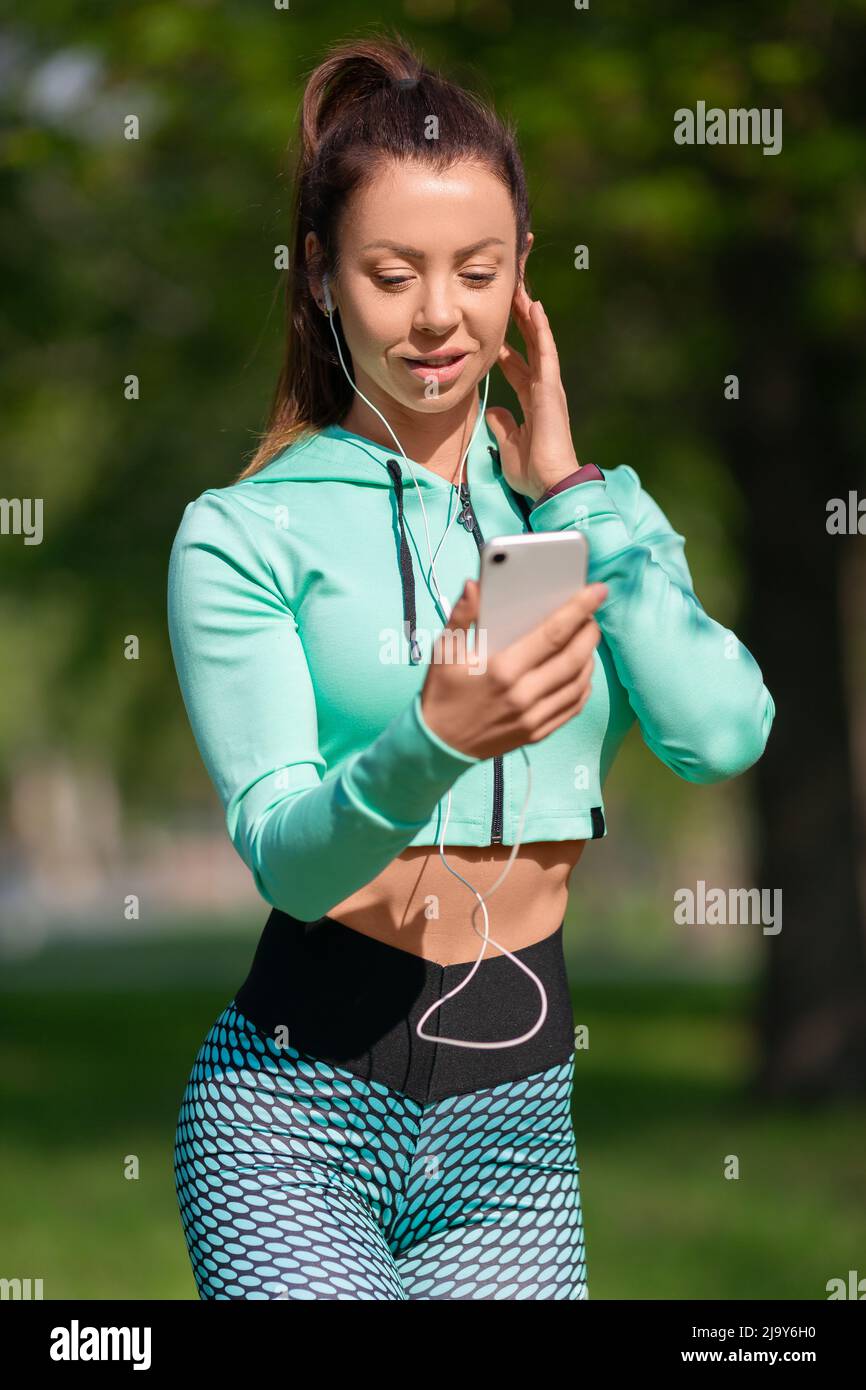 Young woman running in the city park in early morning. Attractive ...