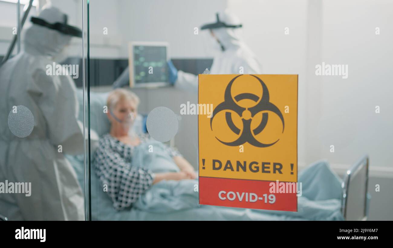 Close up of danger sign on glass of hospital ward for isolated area ...