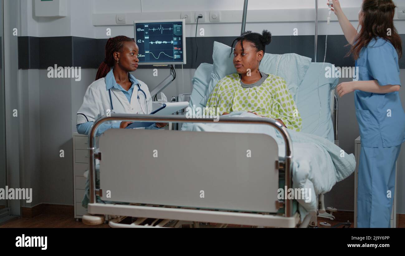 Physician doing healthcare consultation with young patient in hospital ...