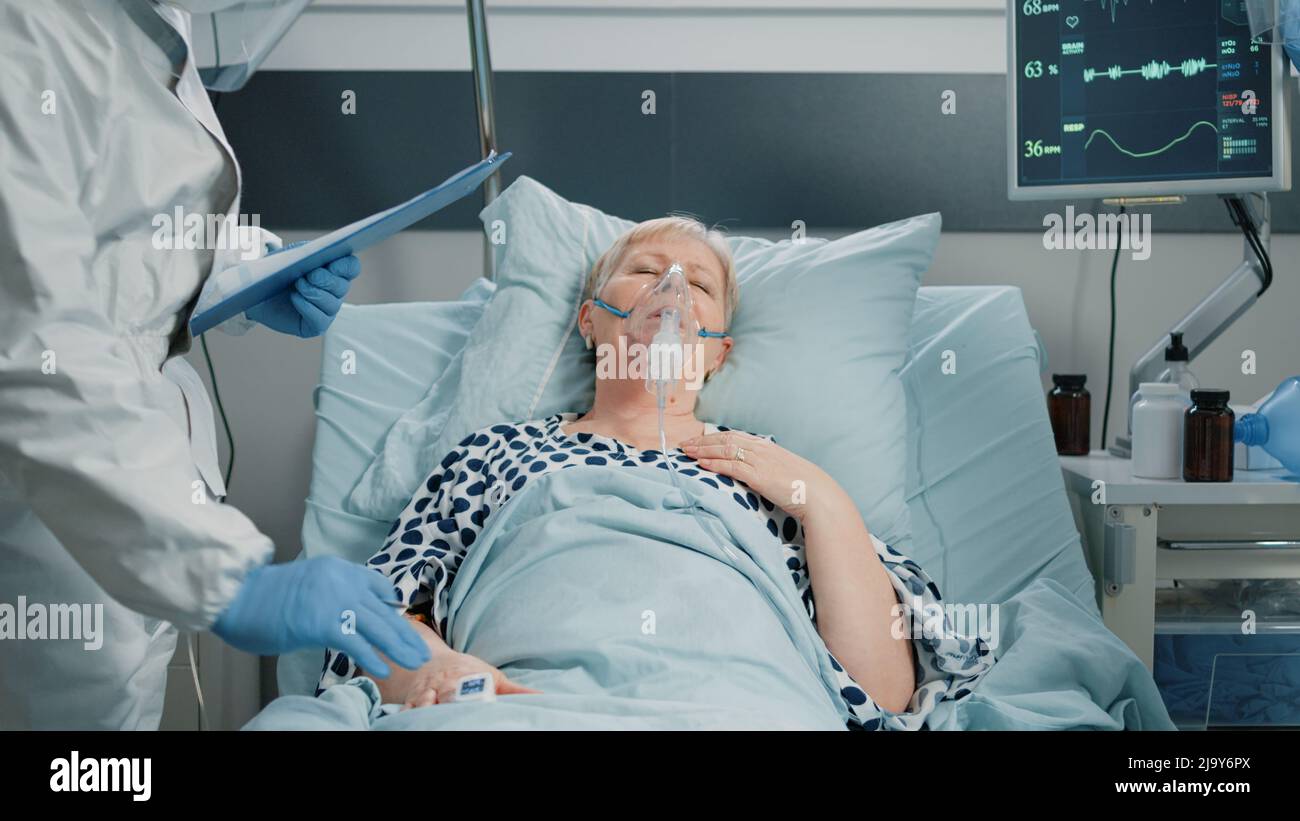 Paramedics consulting heavy breathing woman with oxygen tube in ...