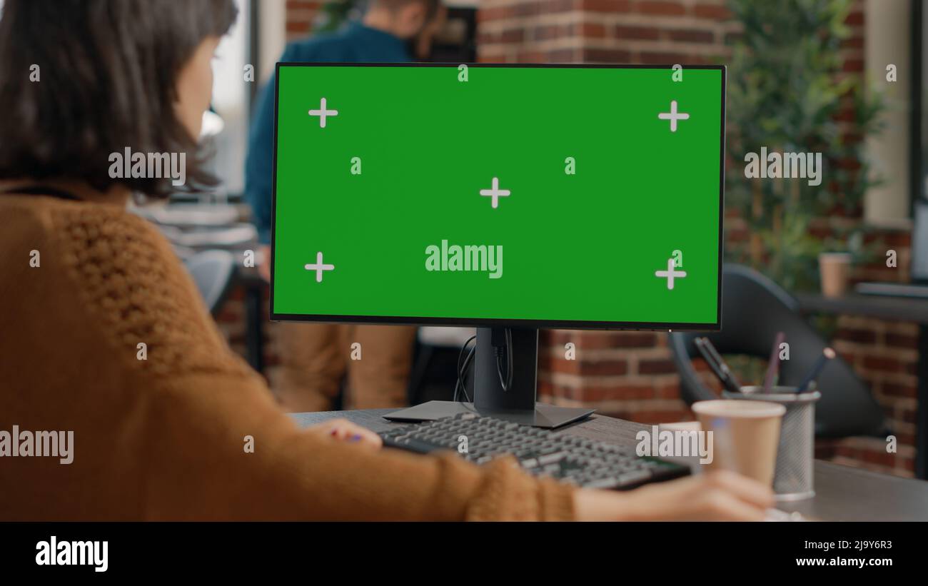 Close up of employee using computer with green screen at desk. Business ...