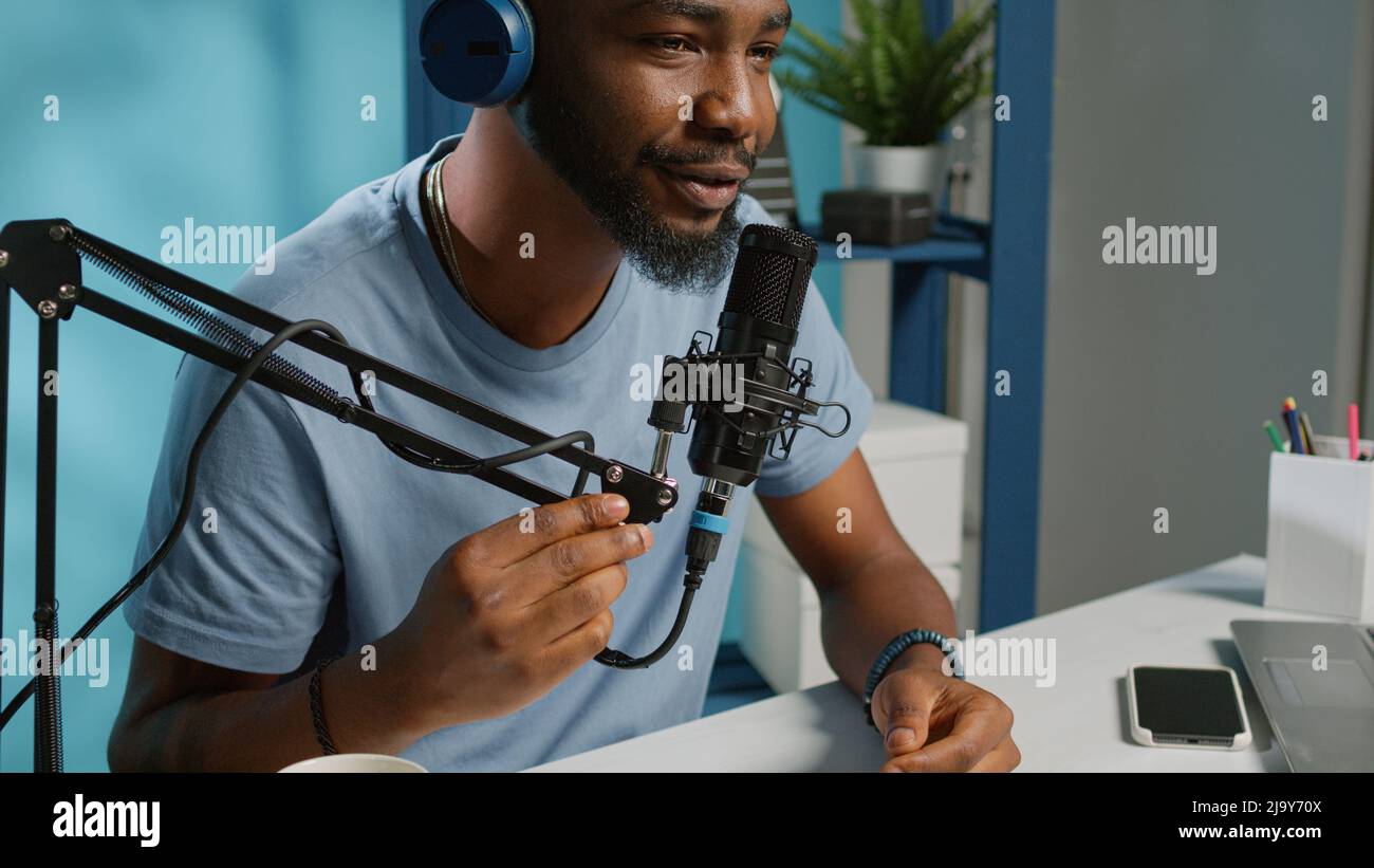 Close up of vlogger using microphone and headphones to record vlog for ...