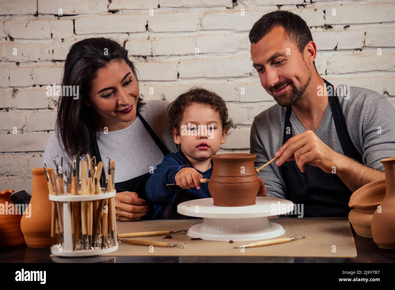 Young happy caucasian family with son working on potter shop .beautiful ...