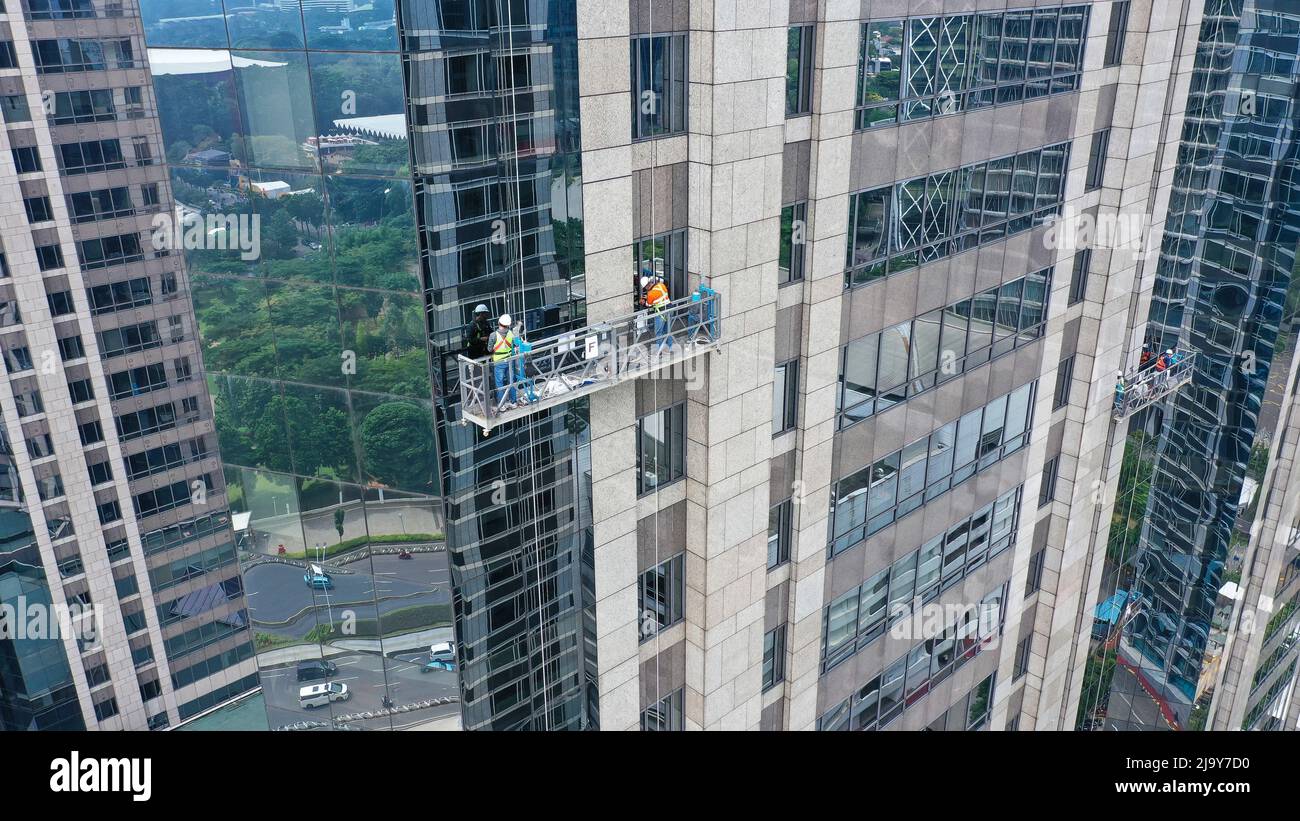 Professional high rise window cleaning service workers in gondola. Two ...