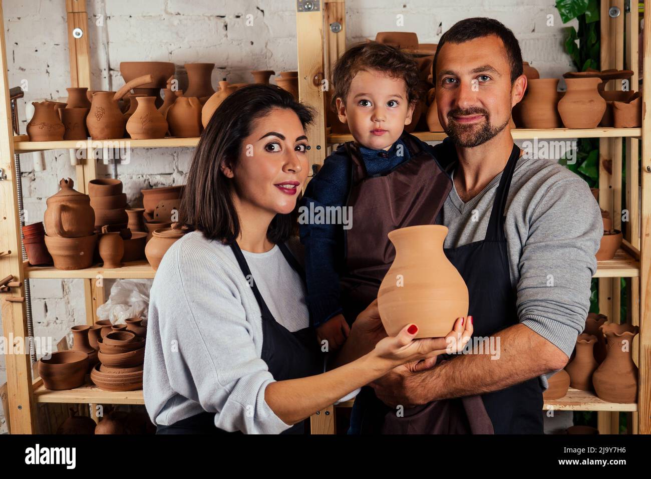 Father , mother and son clay bowl working in pottery workshop ...