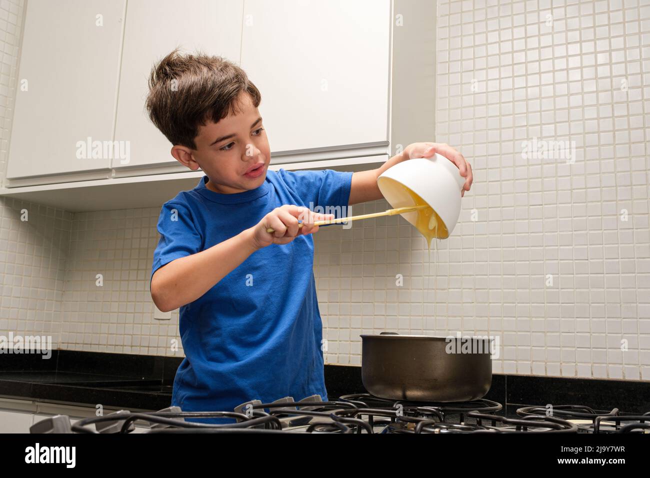 8 year old child pouring condensed milk into the pan and trying to eat ...