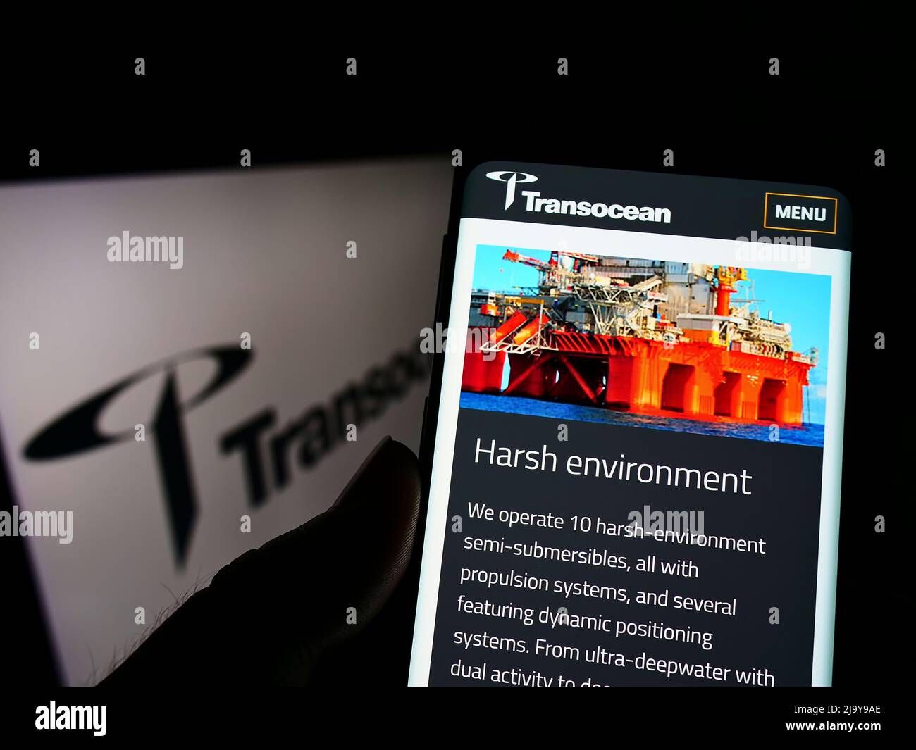 Person holding cellphone with webpage of offshore drilling company ...