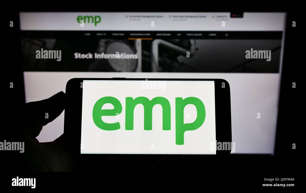 Person holding cellphone with logo of company PT Energi Mega Persada ...