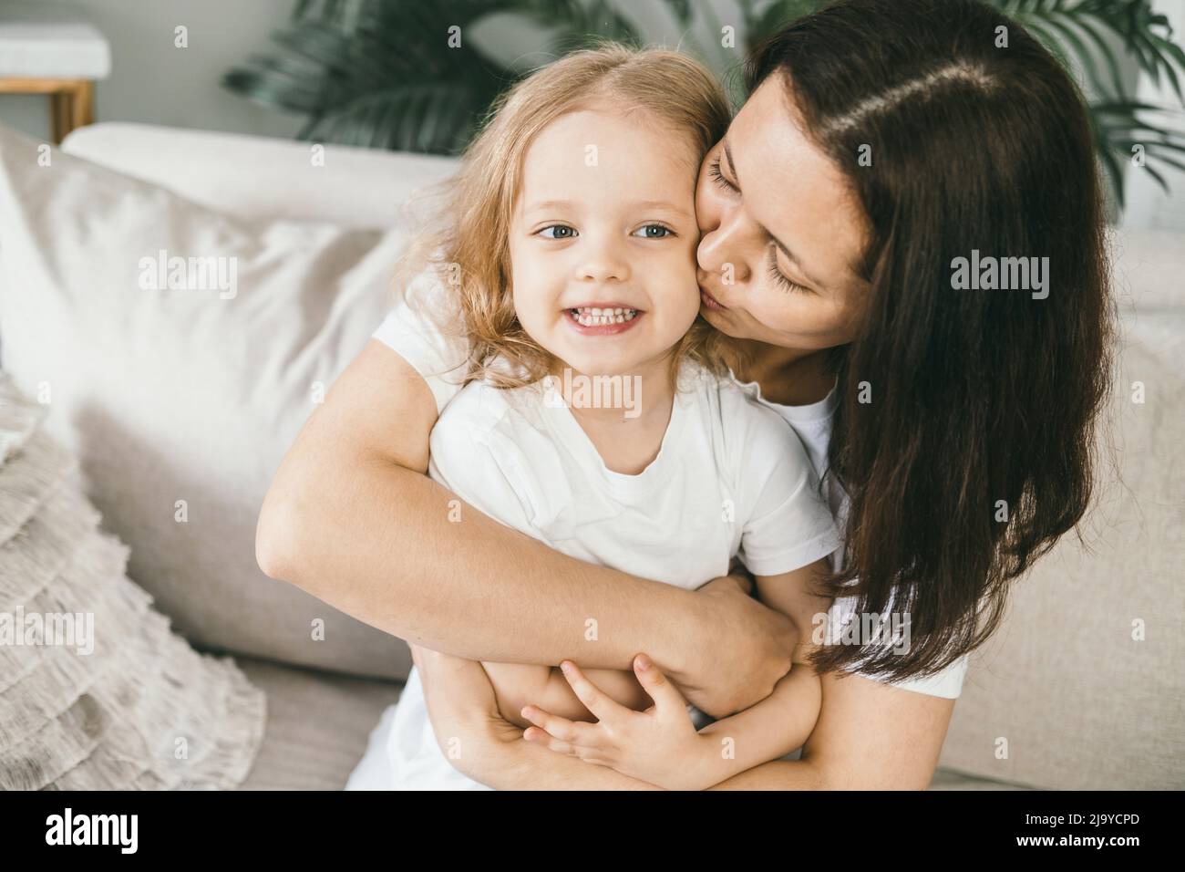 A mother tenderly kisses her four-year-old daughter Stock Photo - Alamy
