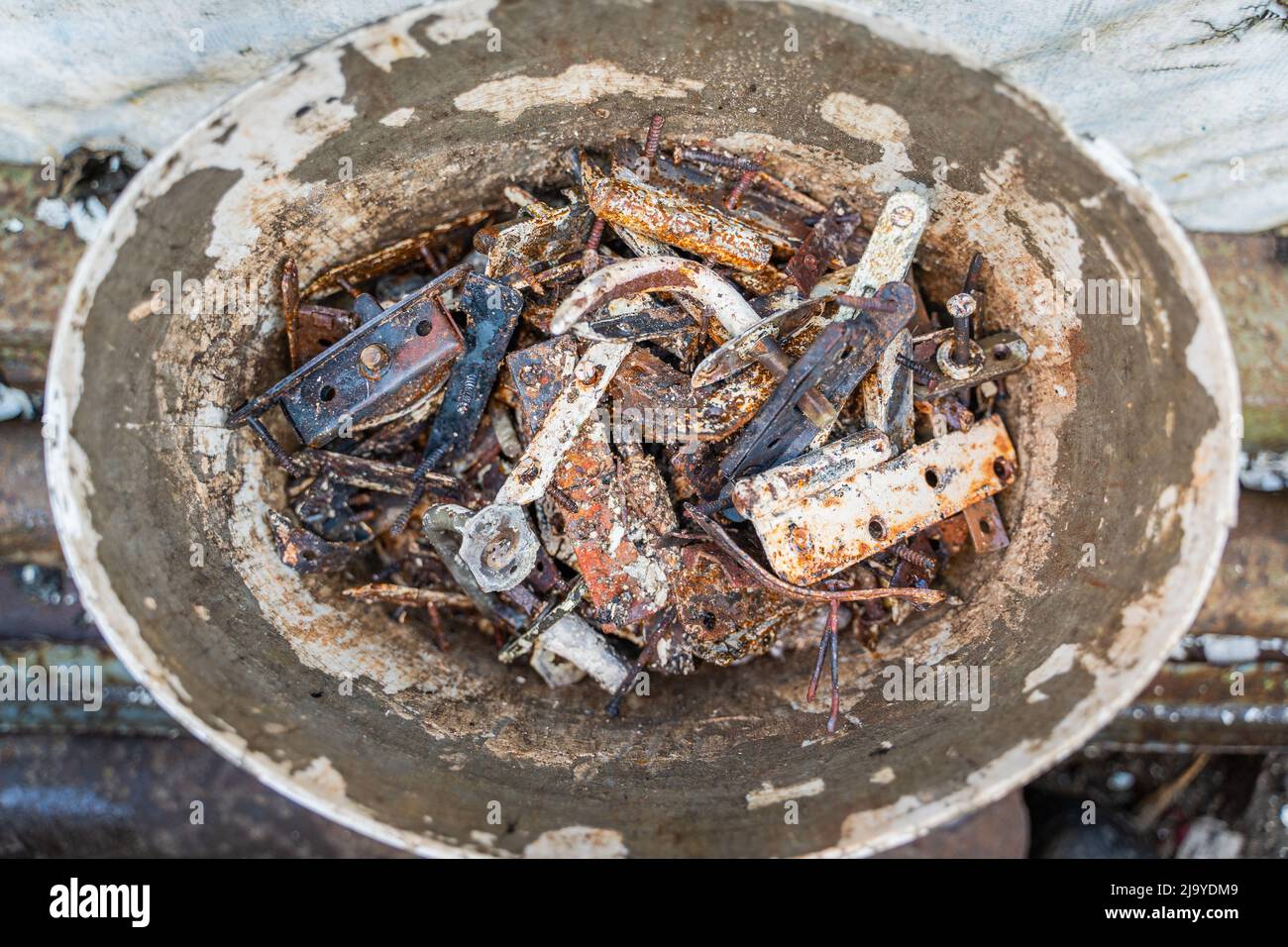 Plastic bucket with scrap metal. Recovered fittings of old wooden ...