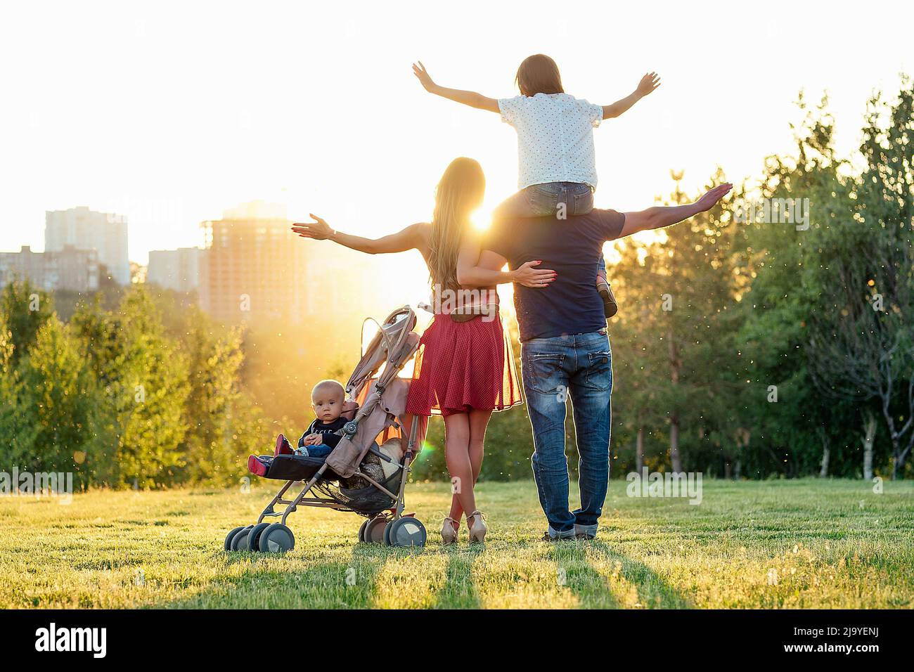 Happy active family photosession in the summer park. beautiful long ...