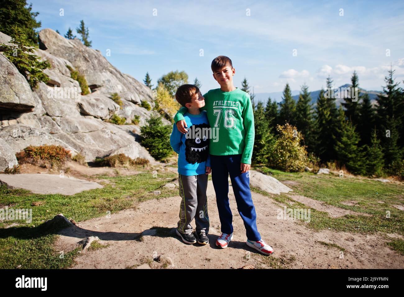 Brothers hike in the mountains, children are walking along a mountain ...