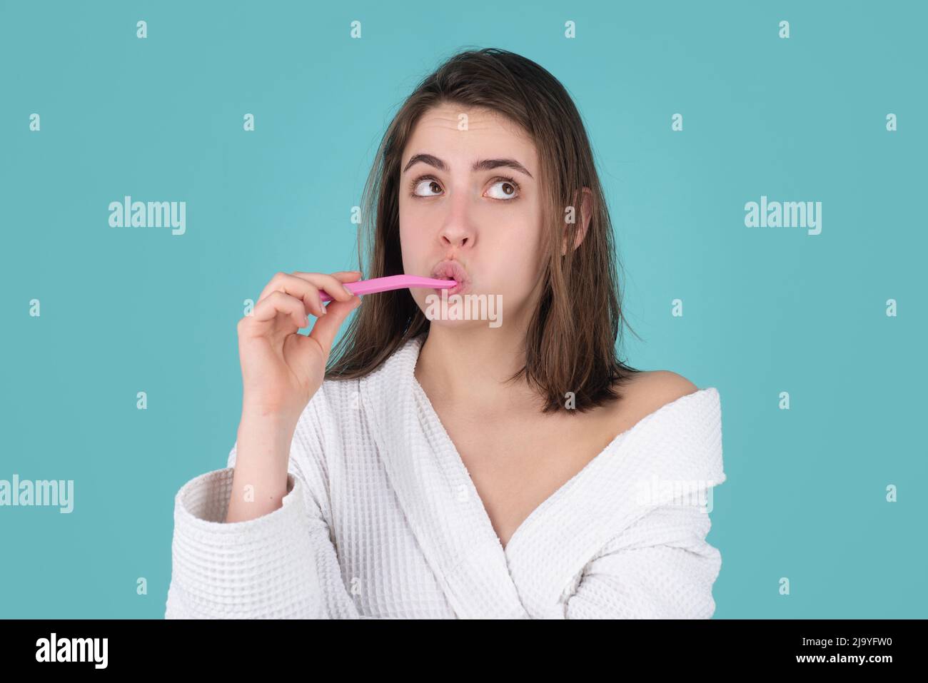 Young cheerful woman brushing teeth with toothbrush during morning ...