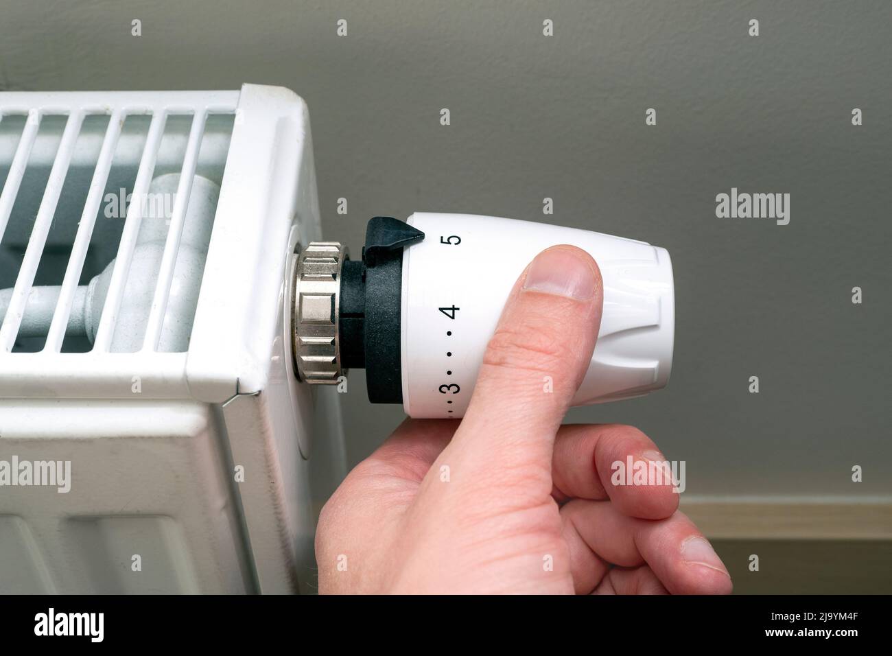 Close-up of hand and heat radiator knob, concept picture about heating ...