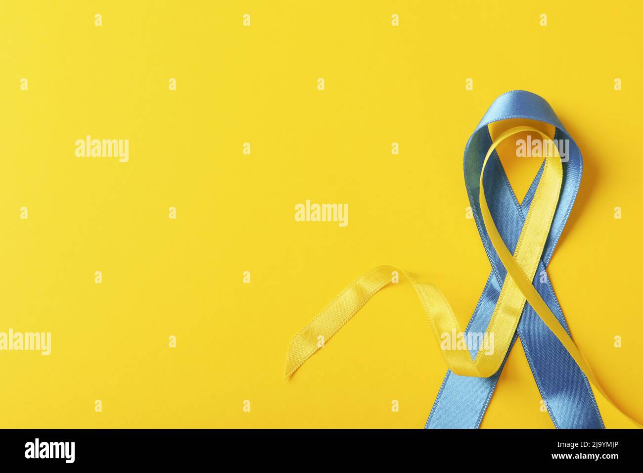 Support Ukraine concept, blue and yellow awareness ribbons on yellow ...