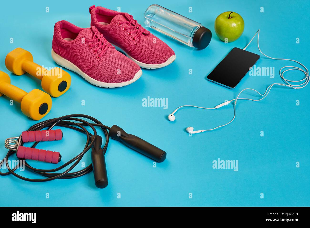 Flat lay of dumbbell, bottle of water, jump rope and sneaker, sport ...