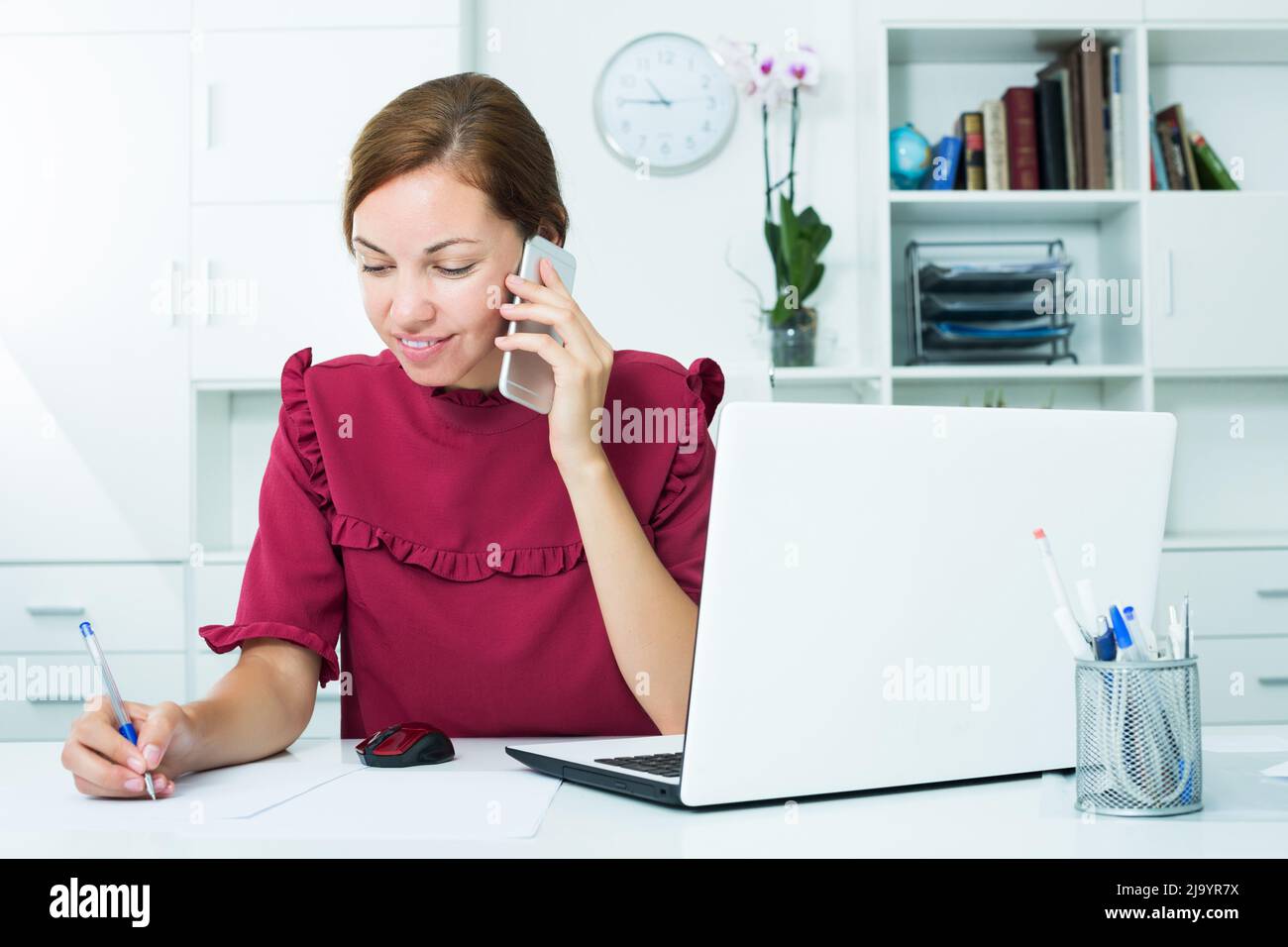 Woman taking notes while talking Stock Photo - Alamy