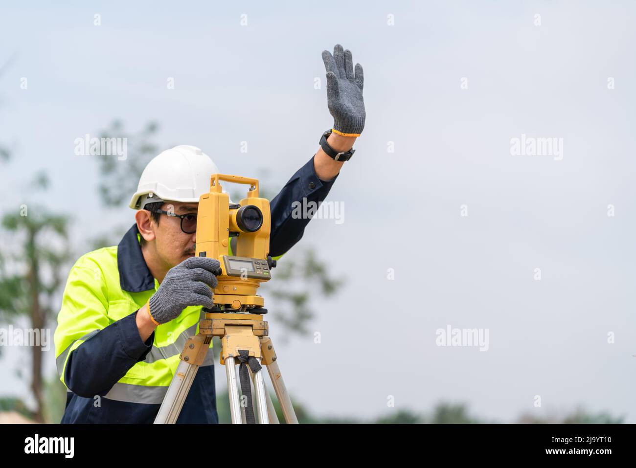 Surveyor Civil Engineer hand signal with equipment on the construction ...