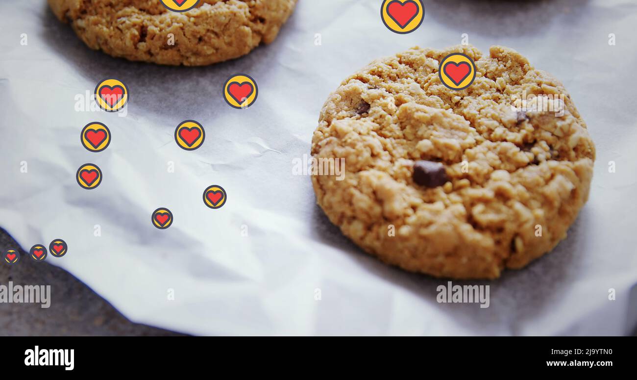 Image of hearts floating over cookies on cooking paper Stock Photo - Alamy