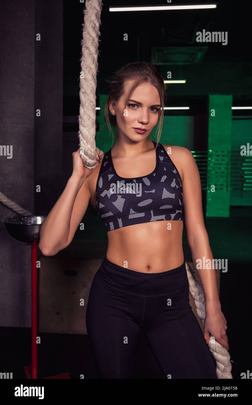 Shot of an attractive female crossfit athlete with a rope at the gym ...