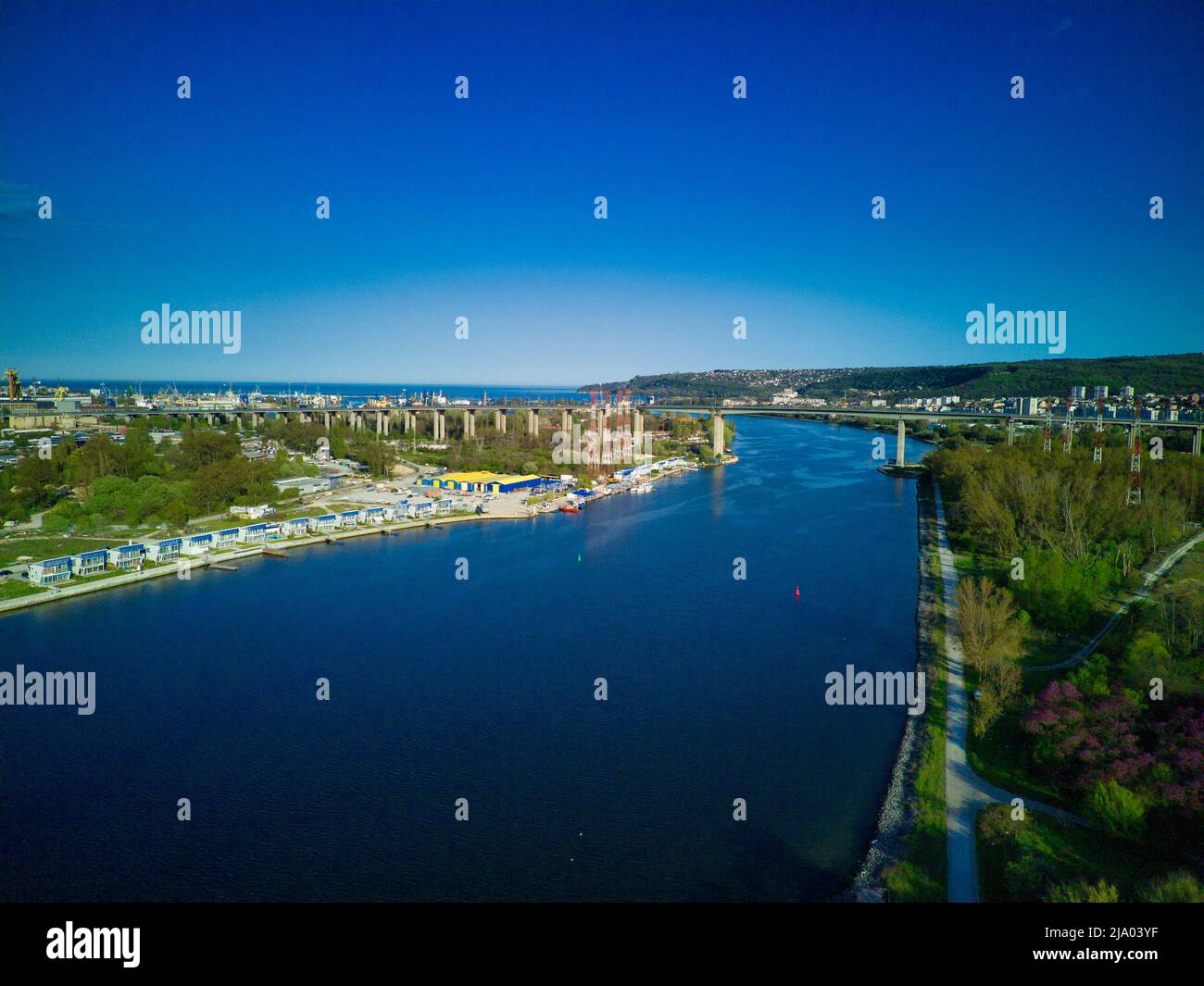 Bird's eye view of concrete sturdy road bridge between land of modern ...