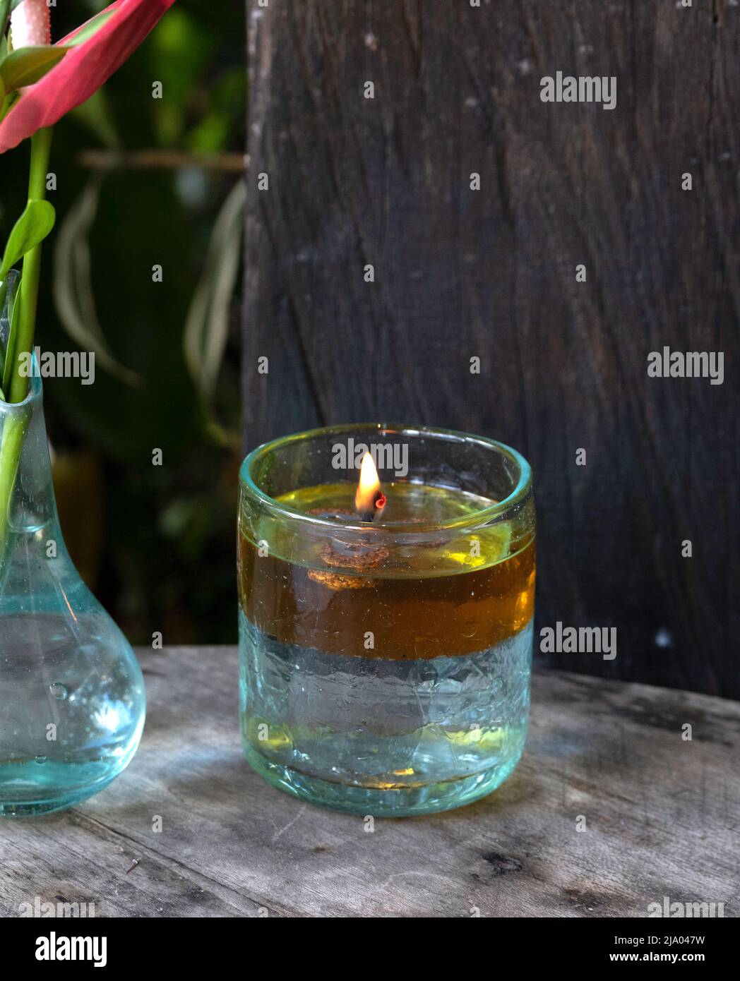Floating flame burning in a thick water glass shape container on wooden ...
