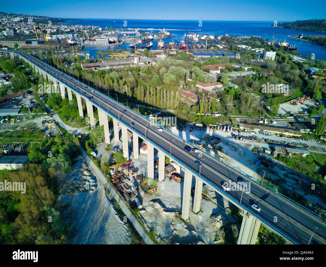 Bird's eye view of concrete sturdy road bridge between land of modern infrastructure seaside ...