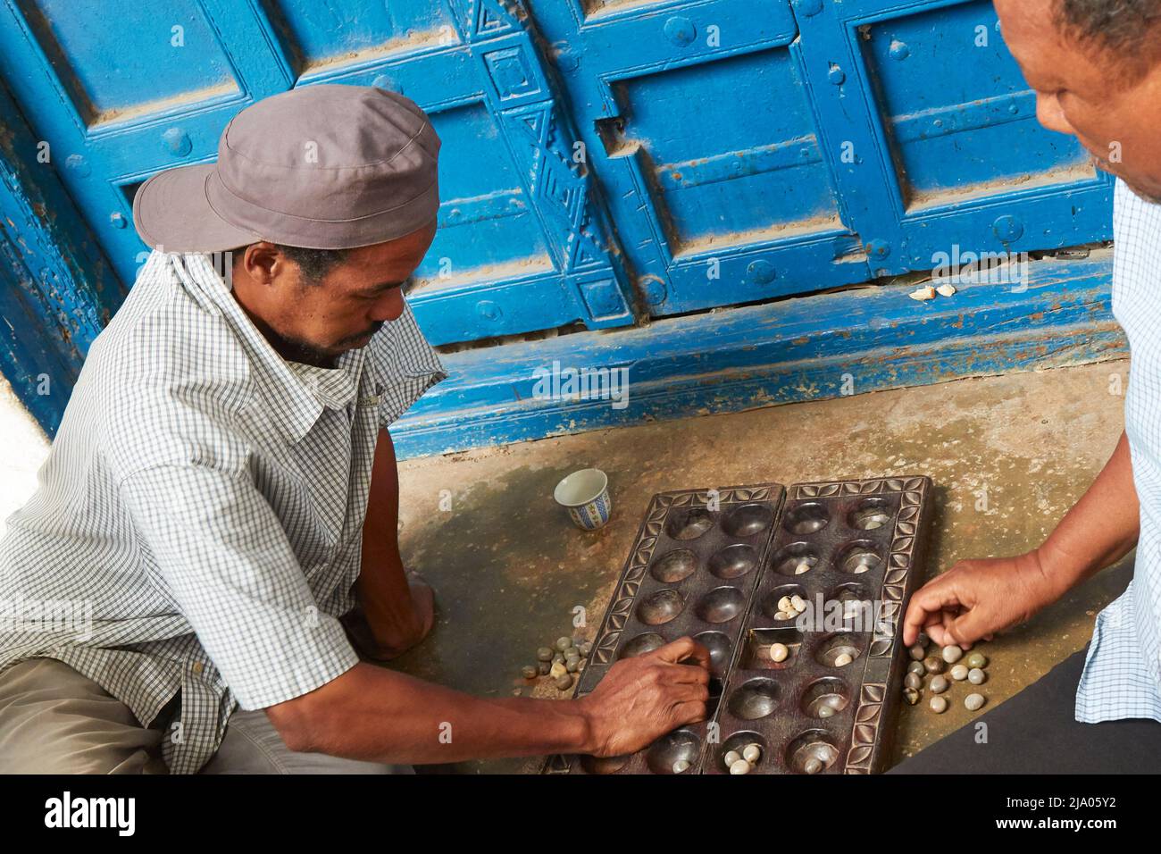 Two men play the "Bao" game in a street in Stone Town, Zanzibar ...