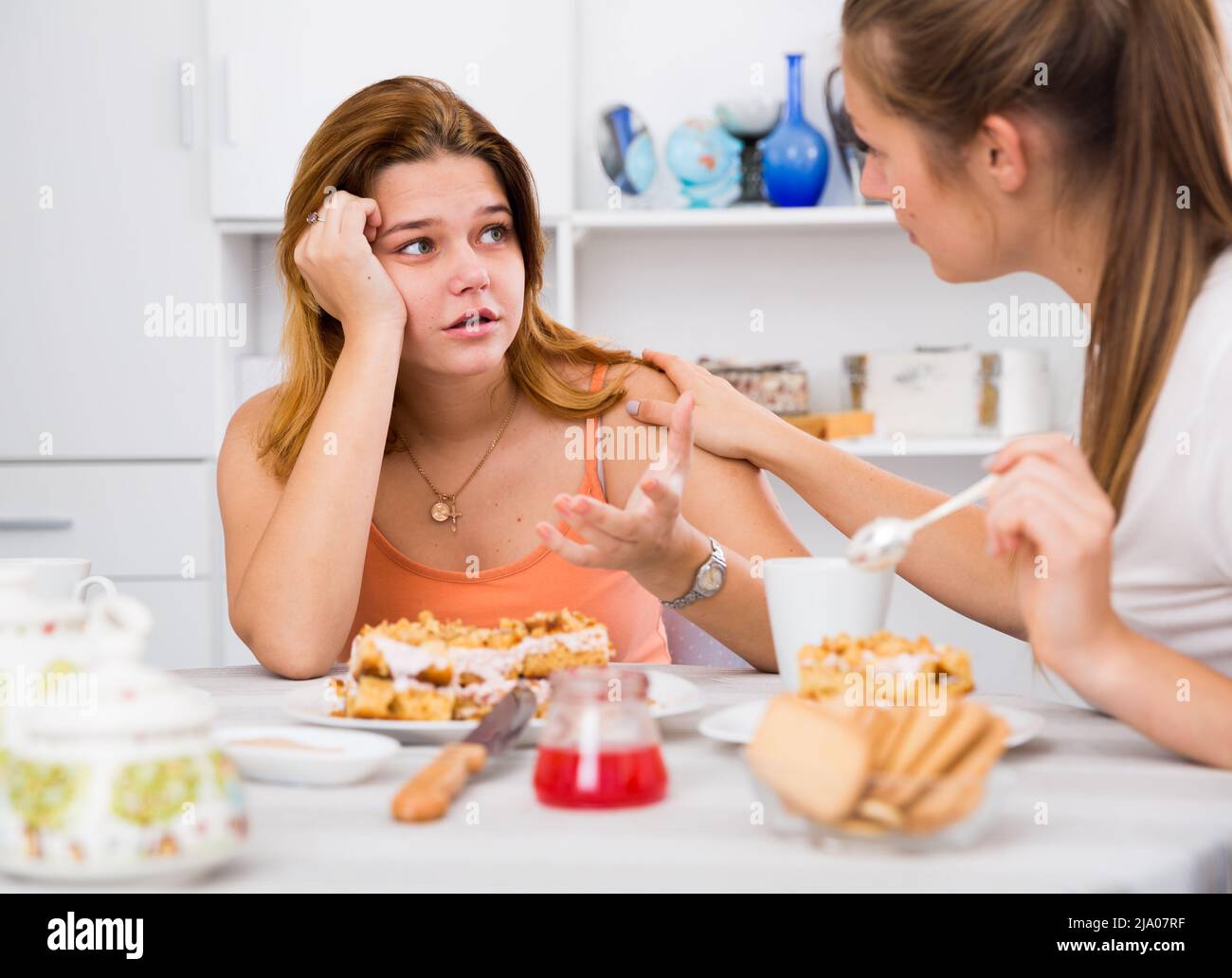 Female talking with young sad friend at home Stock Photo - Alamy