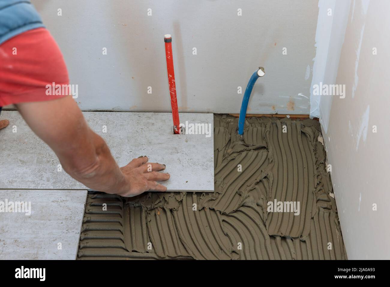 Floor tile installation witht tiler placing porcelain tile Stock Photo ...