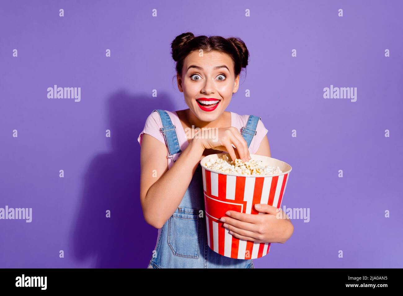 Portrait of positive crazy girl toothy smile amazed watch film eat ...