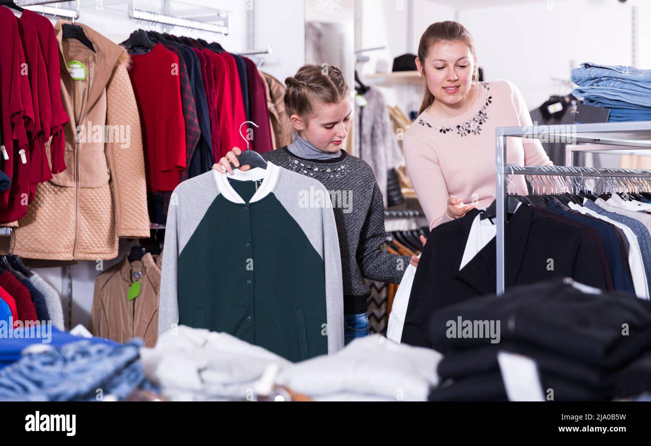 Glad teen girl looking for clothing with mum Stock Photo - Alamy