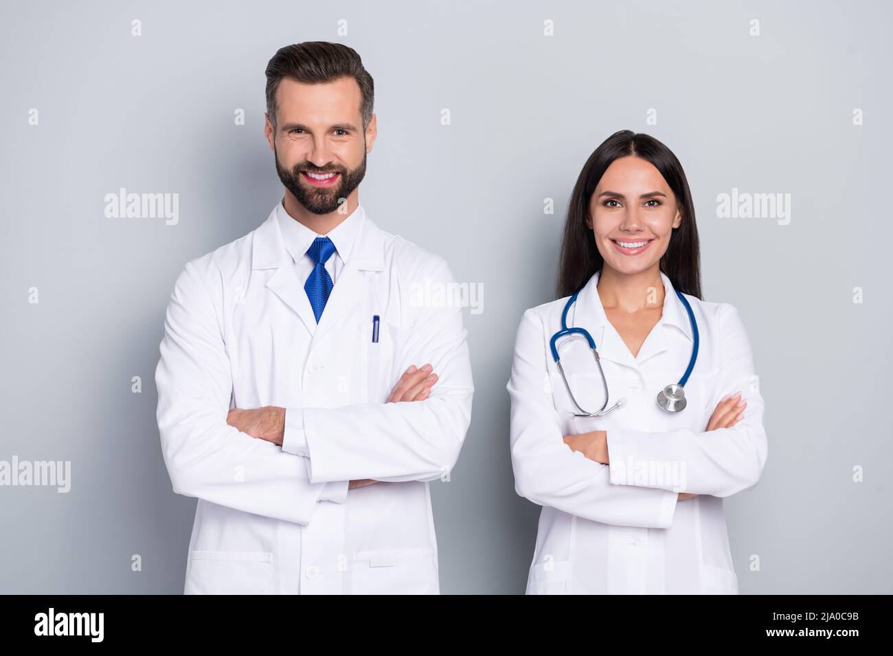 Portrait of two attractive cheerful skilled smart medics folded arms ...