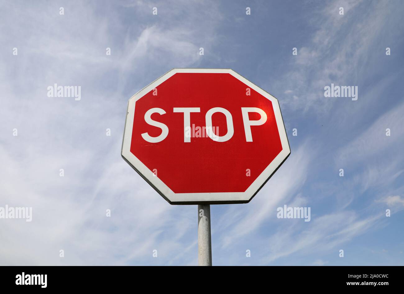 Seasonal weather, a stop-sign at a crossing next to a country road ...