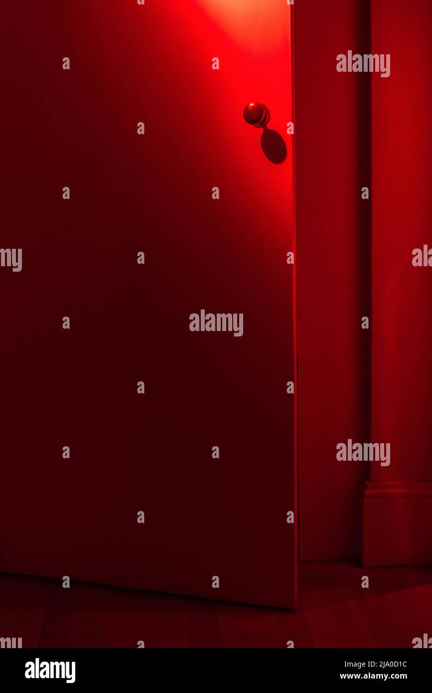 Opened door with red light shone onto it Stock Photo - Alamy