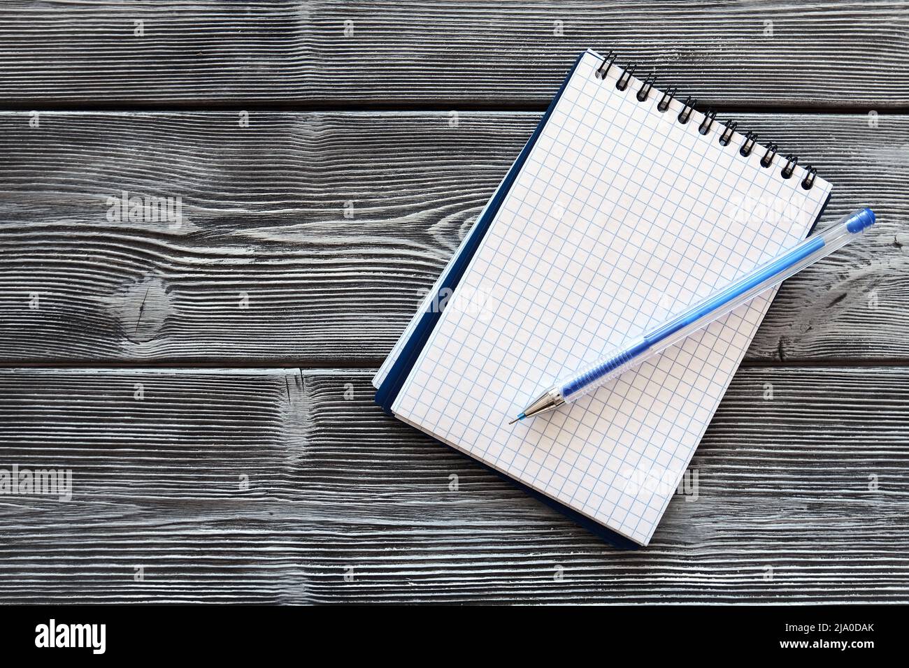 Spiral notebook on the table. There is a ballpoint pen next to it for ...